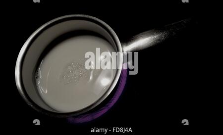 Milk boiling over a pan Stock Photo - Alamy