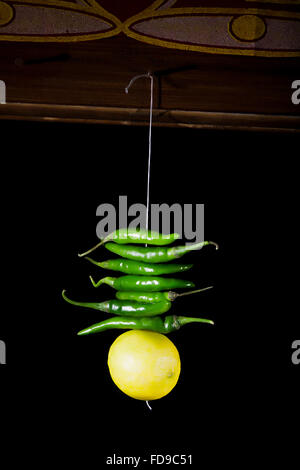 Lemon and green chili peppers hanging on the door. Indian tradition to ...