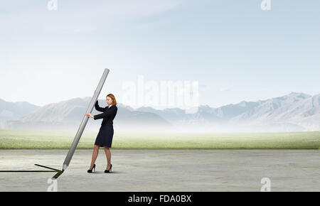 Young businesswoman drawing arrow with big pencil Stock Photo - Alamy
