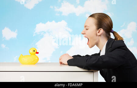 Young businesswoman screaming on yellow rubber duck toy Stock Photo - Alamy