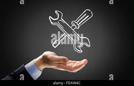 Businessman's hand holding tools over gray background Stock Photo - Alamy