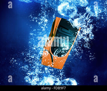 Computer sinking and dissolving in clear blue water Stock Photo - Alamy