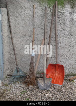 Old used garden tools shovel and rake. Image toned in Peach Fuzz color ...