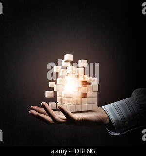 Businessman hand shows disintegrating cube in palm Stock Photo - Alamy