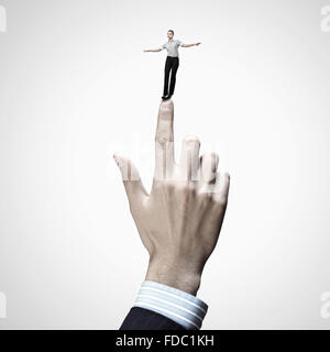Young businesswoman balancing on finger of businessman Stock Photo - Alamy