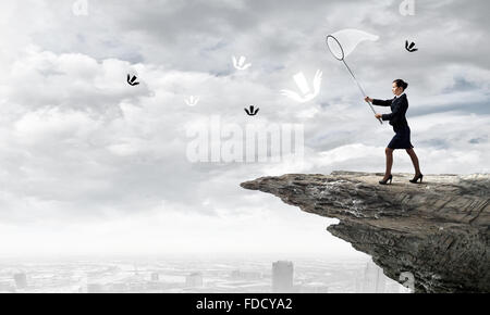 Young businesswoman catching flying marks with hoop Stock Photo - Alamy