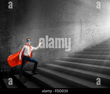 Young superman walking up the stair case Stock Photo - Alamy