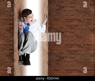 Young man trapped between walls Stock Photo - Alamy