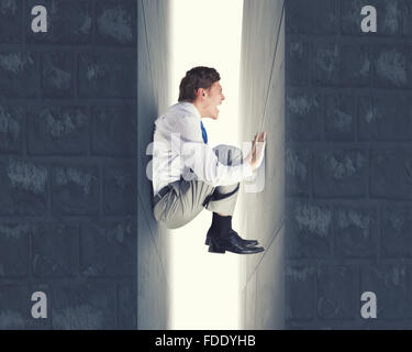 Young troubled businessman trapped between two walls Stock Photo - Alamy