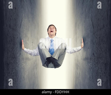 Young troubled businessman trapped between two walls Stock Photo - Alamy
