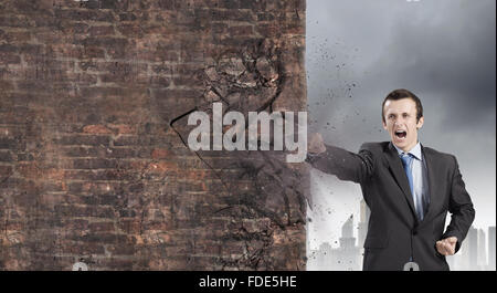 Businessman breaking stone wall with karate punch Stock Photo - Alamy