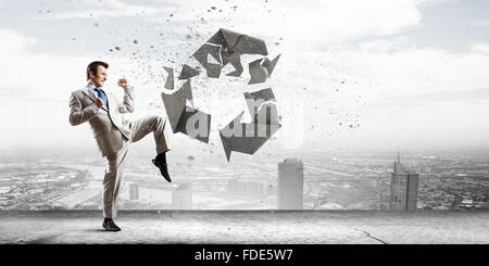 Businessman breaking recycle stone sign with karate kick Stock Photo ...