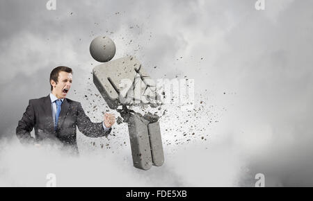Angry young businessman fighting with stone opponent Stock Photo - Alamy