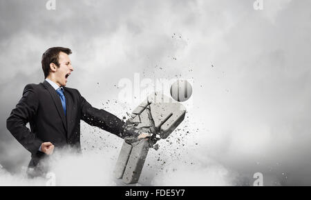 Angry young businessman fighting with stone opponent Stock Photo - Alamy