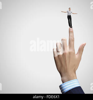 Young businesswoman balancing on finger of businessman Stock Photo - Alamy