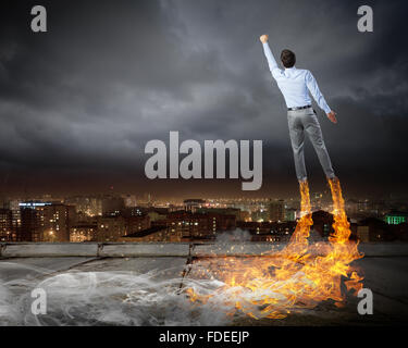 Rear view of businessman superhero flying up in sky Stock Photo - Alamy