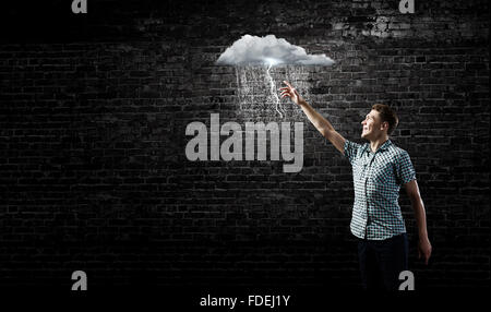 Young man touching illustration of raining cloud Stock Photo - Alamy