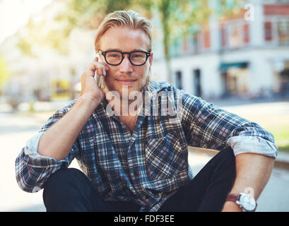 modern life and lifestyle. guy chatting in earphones. smiling ...