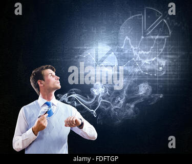 Young businessman smoking pipe with diagrams and graphs at background ...
