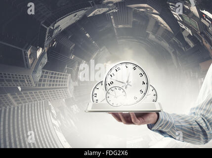 Businessman hold tablet pc with clocks on screen Stock Photo - Alamy