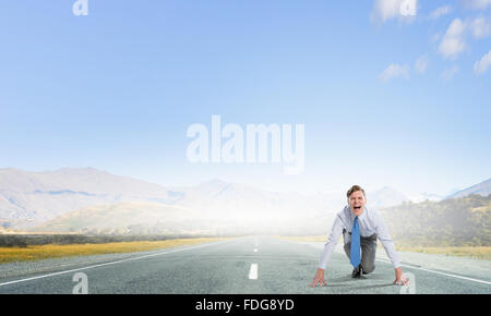 Young determined businessman in starting position ready to compete ...