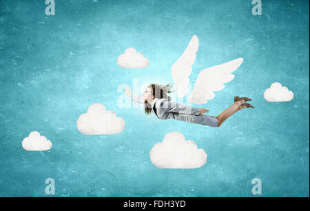 Young businesswoman with drawn wings flying high in sky Stock Photo - Alamy
