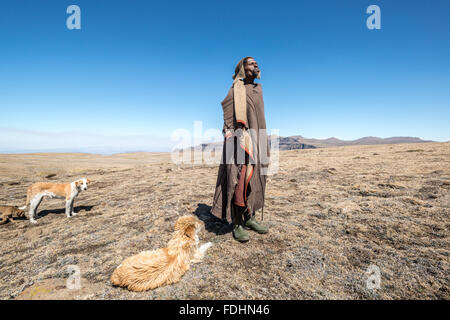 Portrait of a local shepherd with his dogs wrapped in a blanket in the ...