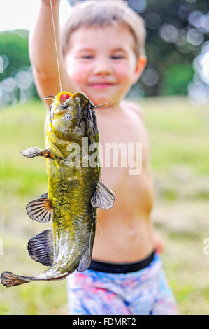 Boy with a fish he caught Stock Photo - Alamy