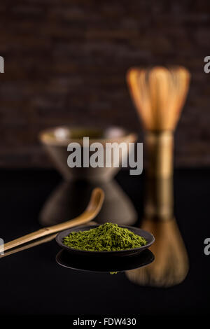 Macha green powder in a plate on black background Stock Photo - Alamy
