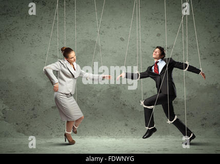Image of businesspeople hanging on strings like marionettes against ...