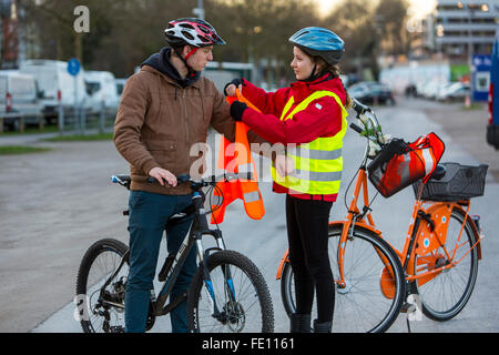 Cyclist put on safety clothing, bike helmet and reflecting vest for ...