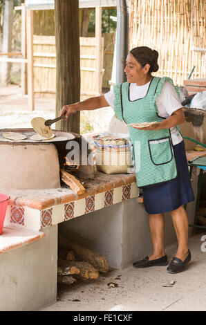 Mexico, Oaxaca, Woman making tortillas outside on traditional comal ...
