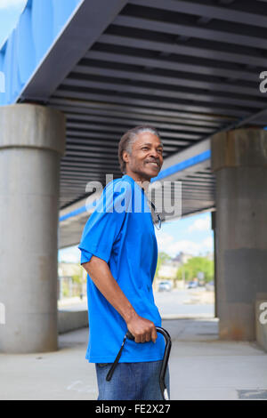 Man with Traumatic Brain Injury taking a walk with his cane near a ...