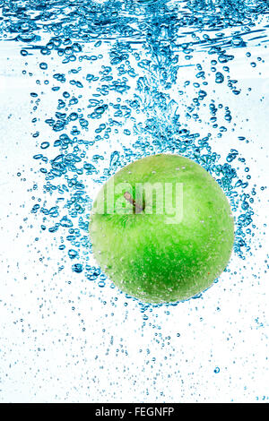 Green apple with water splash on blue background Stock Photo - Alamy