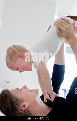 Mature man holding up toddler son Stock Photo - Alamy