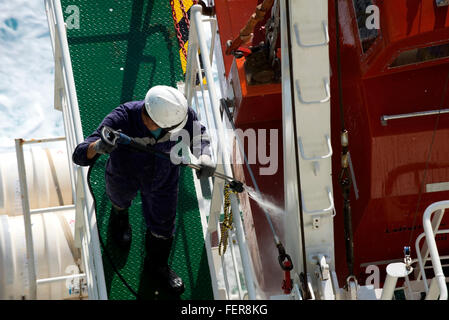 Container ship crew member works on the deck of Utrillo cargo vessel ...