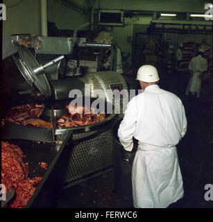 This image from 1970 depicts the process of beef portion cutting, a ...