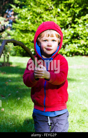 Young boy playing with a stick Stock Photo - Alamy