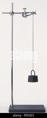 Spring in clamp pulled by weight Stock Photo - Alamy