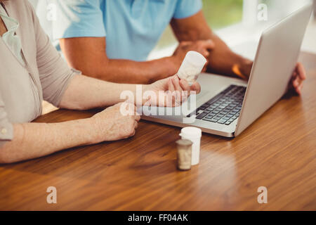 Senior couple with pills using laptop Stock Photo - Alamy