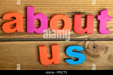 Help Us and Help Me concept. Wooden letters and colored pieces of chalk ...