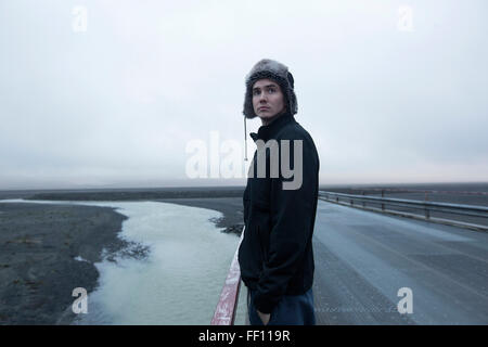 Young caucasian man standing over blue background covering eyes with ...