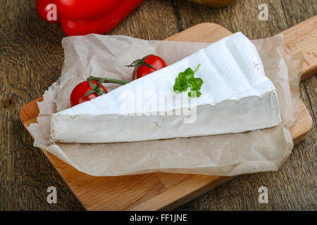 Brie cheese triangle with tomato and parsley Stock Photo - Alamy