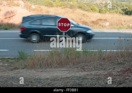 Car passing behind a Stop sign Stock Photo - Alamy
