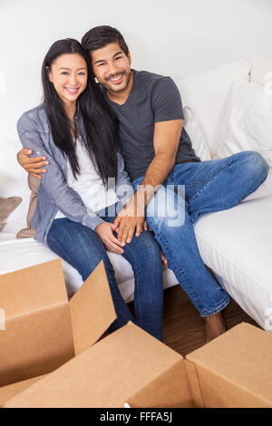 Happy young couple unpacking or packing boxes and moving into a new ...
