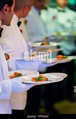 Waiters serve food at a gala dinner closing the 10th annual cigar ...