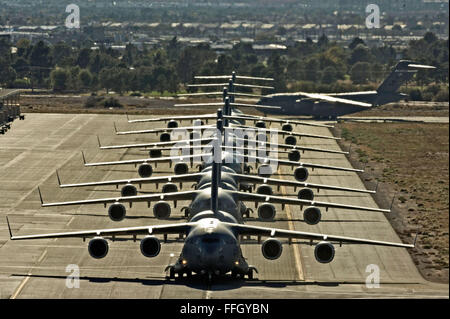An Air Force C-130 Globemaster III prepares for takeoff while members ...