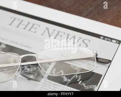 E-reader with newspaper application and glasses Stock Photo - Alamy