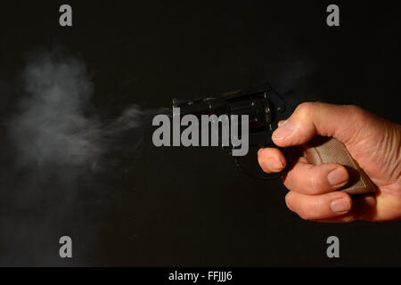 Small revolver smoking after firing. Held in male hand. (Toy Gun Stock ...