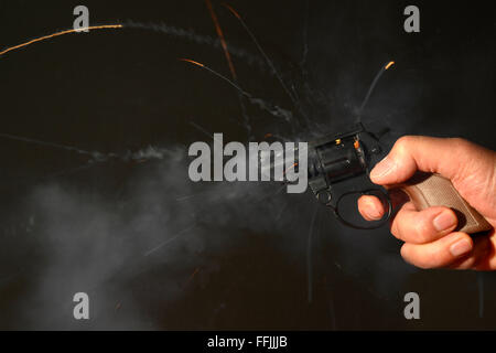 Small revolver smoking after firing. Held in male hand. (Toy Gun Stock ...